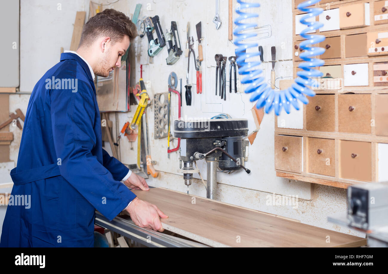 Young smiling american guy using drilling machine at workshop Stock ...