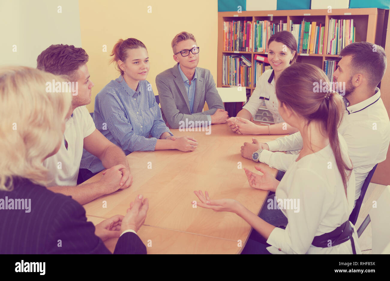 Group of attentive students and female professor working together at ...