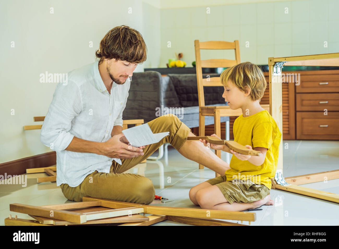 Father and son assembling furniture. Boy helping his dad at home. Happy ...