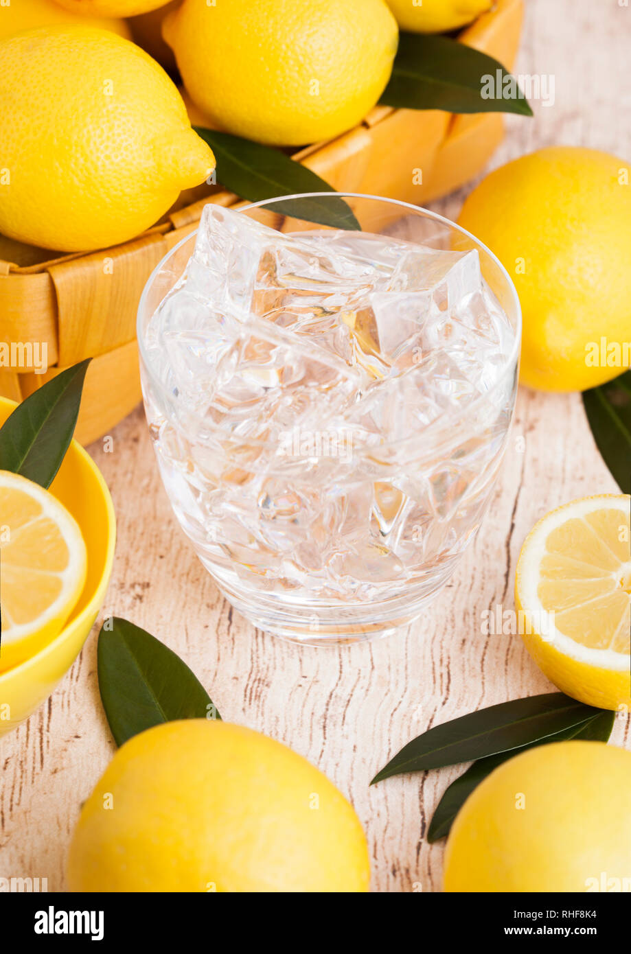 Glass of organic fresh lemon still summer water with raw lemons on ...