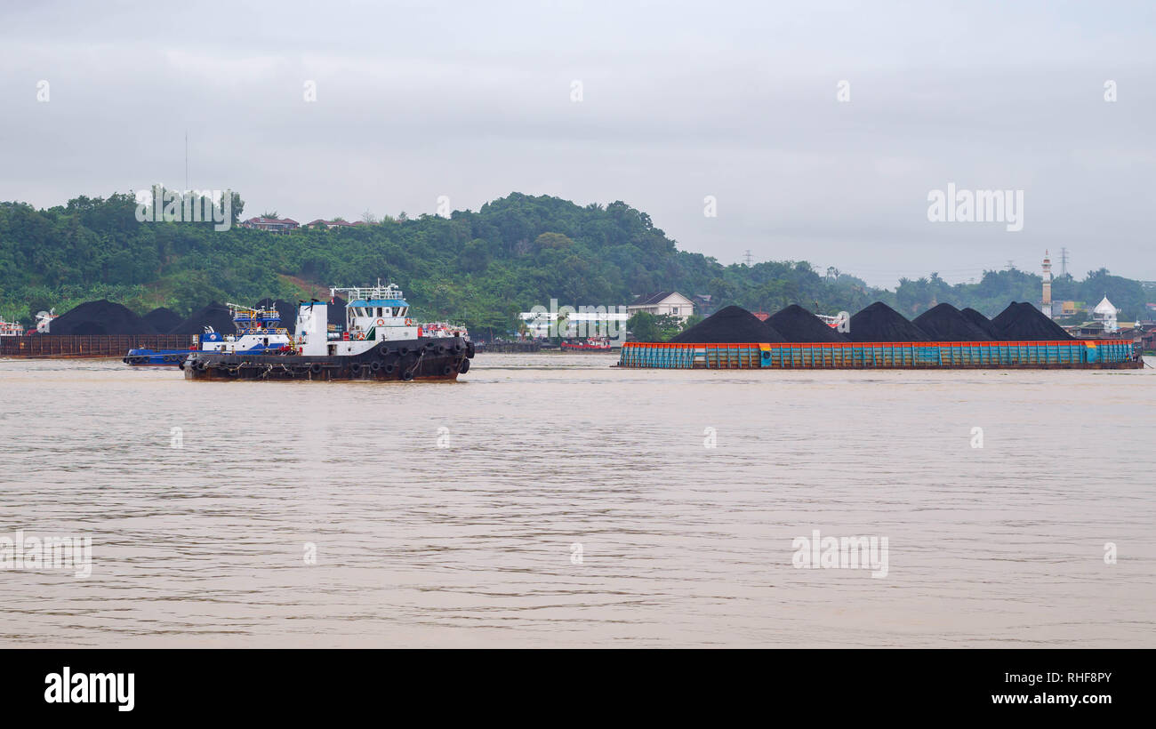 tugboat with barge full of coal cruising Mahakam River, Samarinda ...