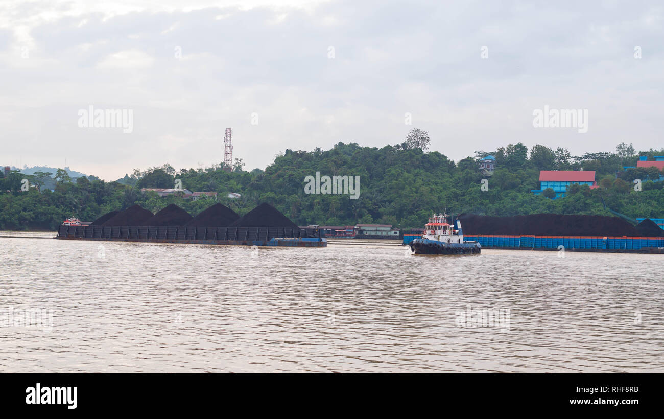 tugboat with barge full of coal cruising Mahakam River, Samarinda ...