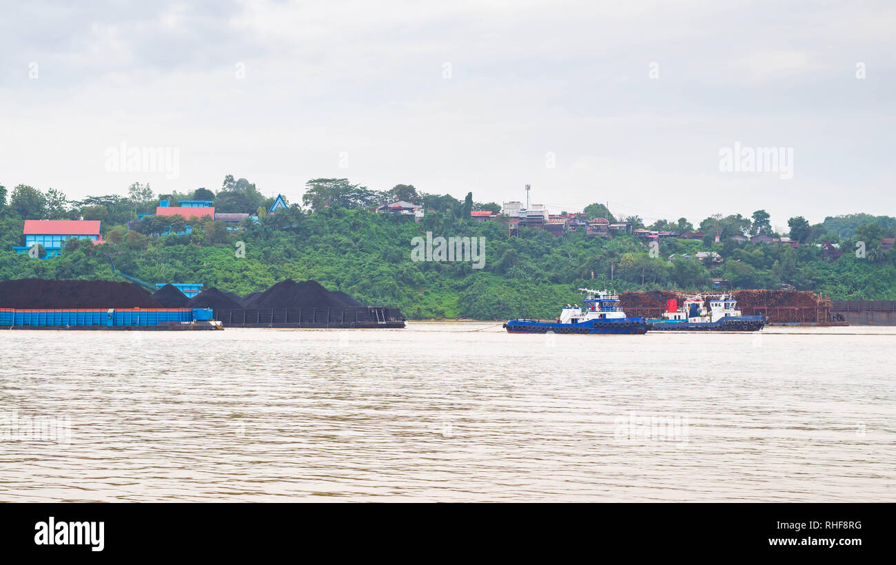 tugboat with barge full of coal cruising Mahakam River, Samarinda ...