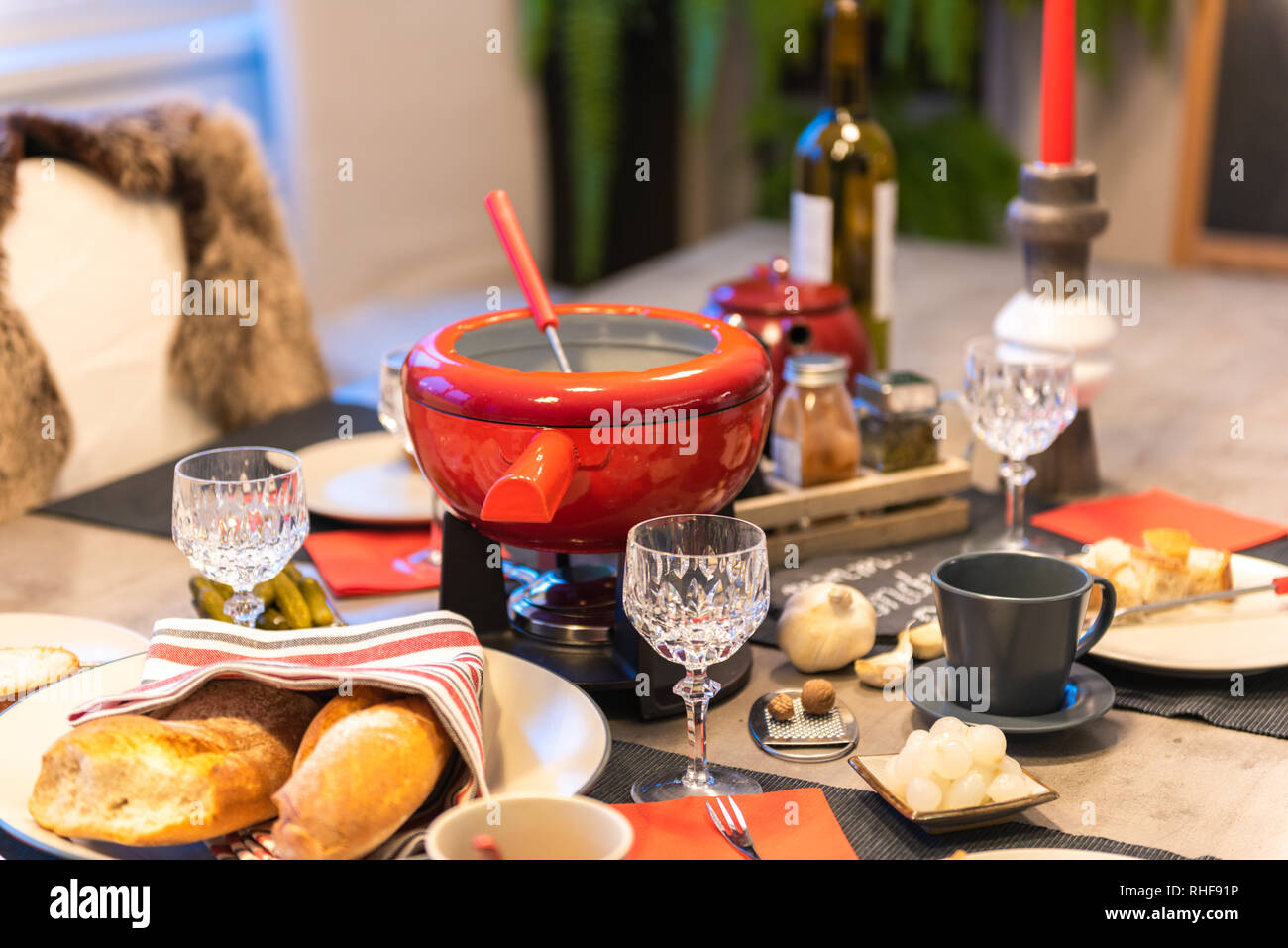 Traditional swiss cheese fondue in a red pot on concrete dining table ...