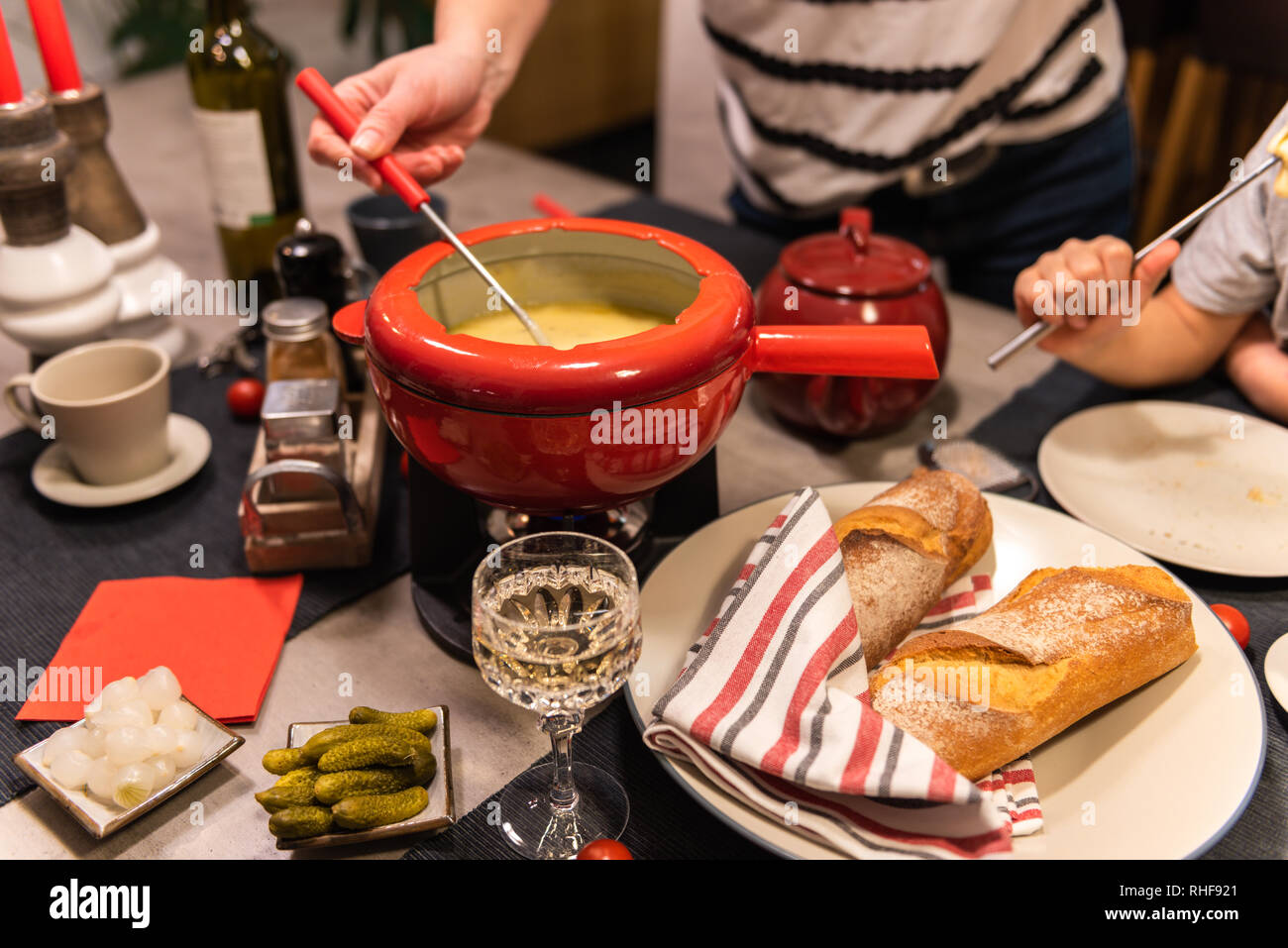 Traditional swiss cheese fondue in a red pot on concrete dining table ...