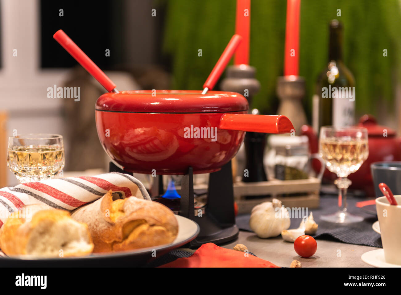 Traditional swiss cheese fondue in a red pot on concrete dining table ...