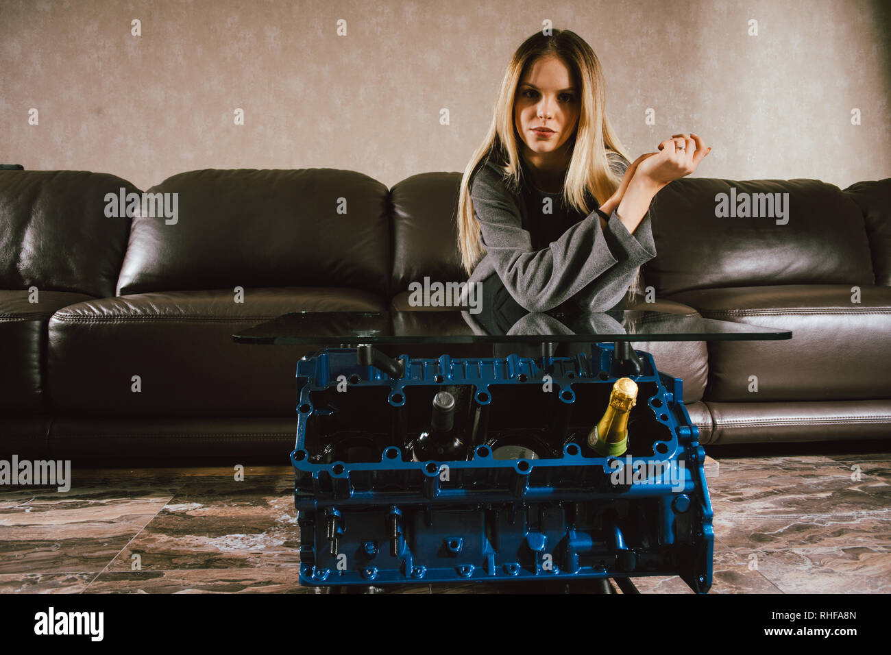 Young caucasian blonde girl sitting on sofa at luxury interior with ...