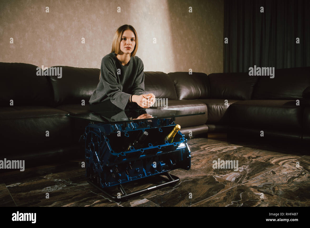 Young caucasian blonde girl sitting on sofa at luxury interior with ...