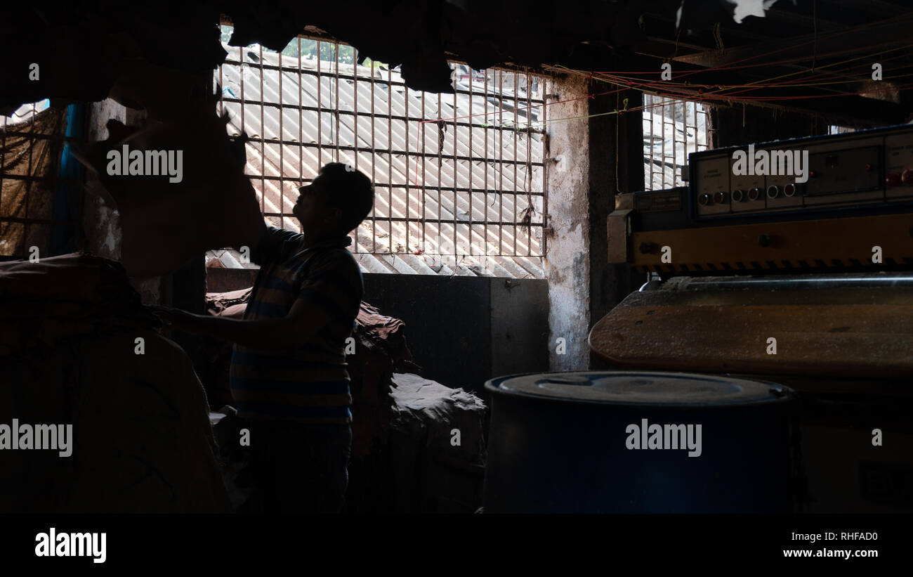 man work hard in the leather factory inside the dharavi slum in mumbay ...
