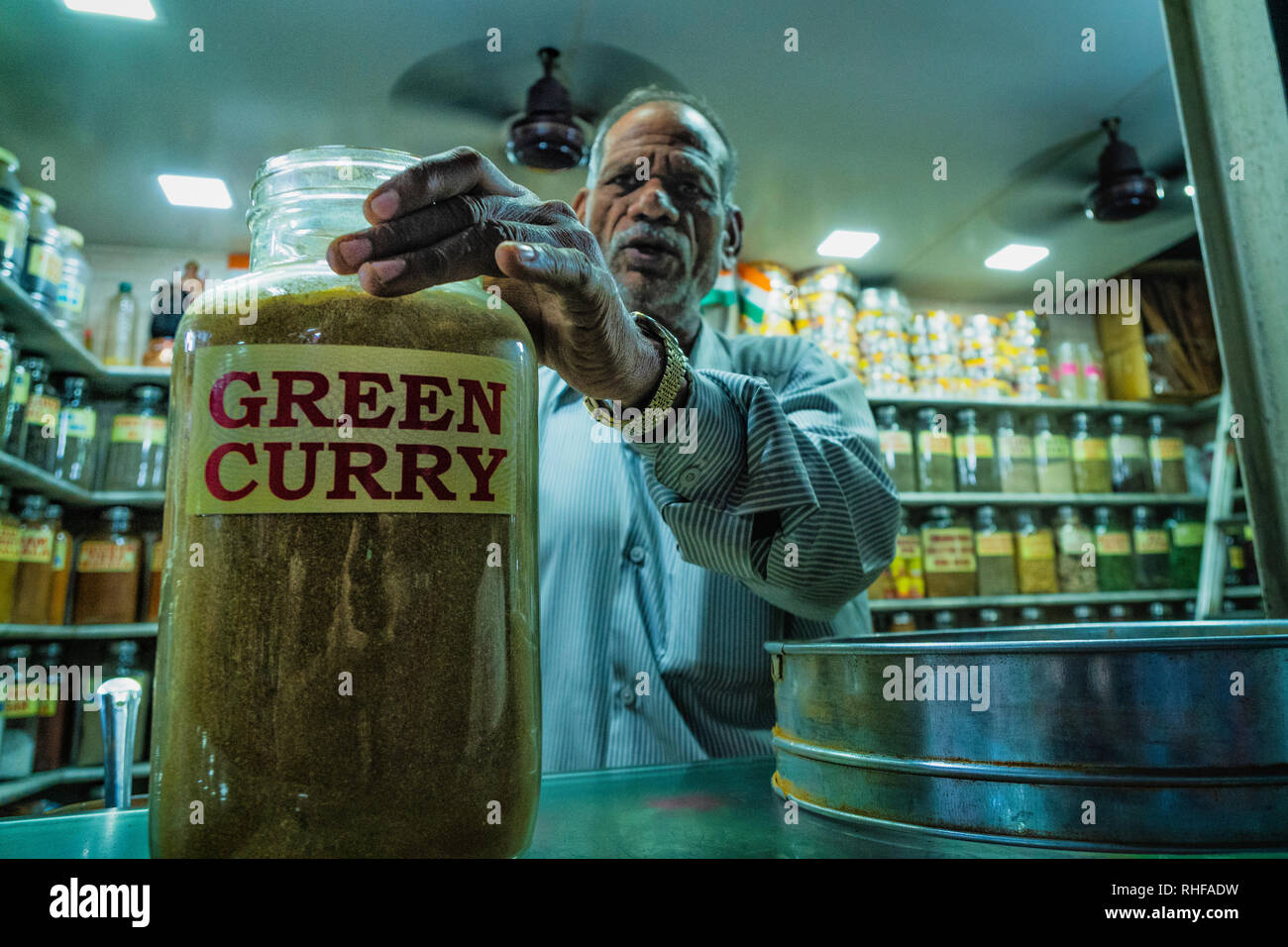 old indian man with big glass jar of hot curry Stock Photo - Alamy