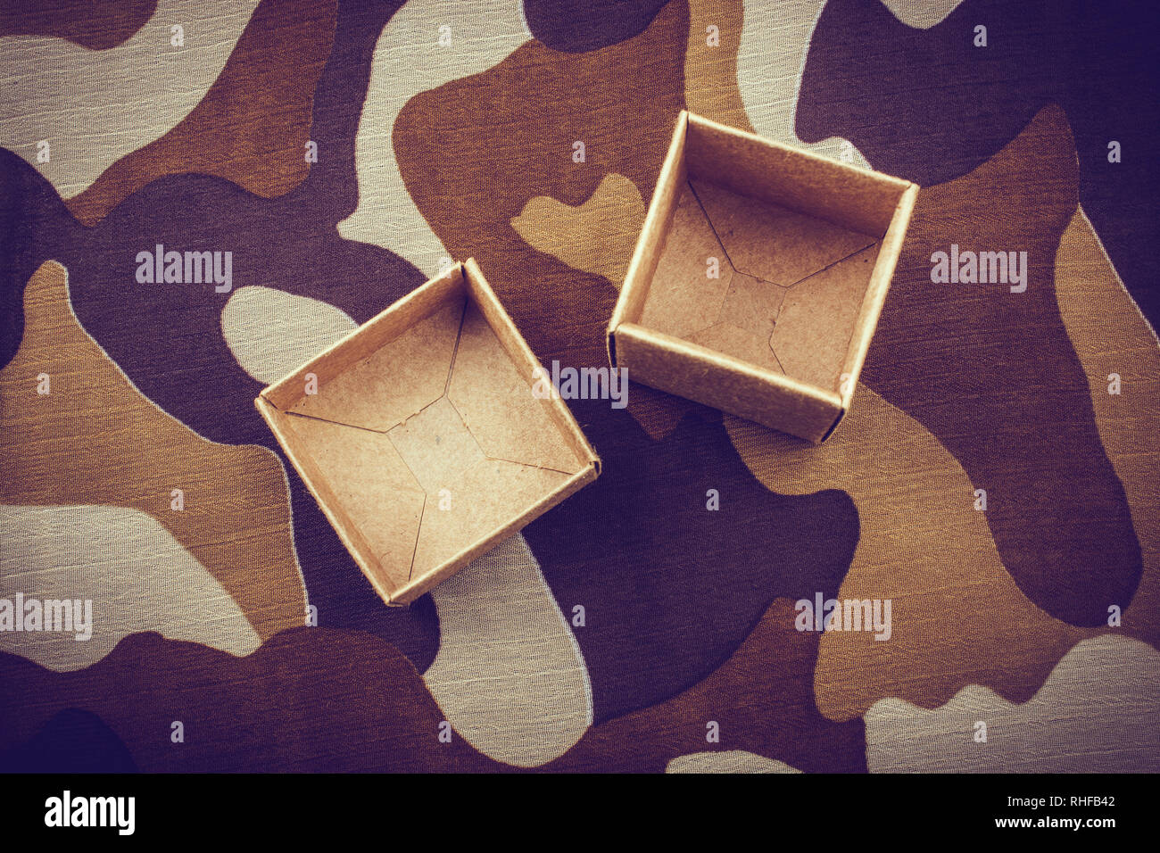 Two open cardboard boxes on a camouflage background Stock Photo - Alamy
