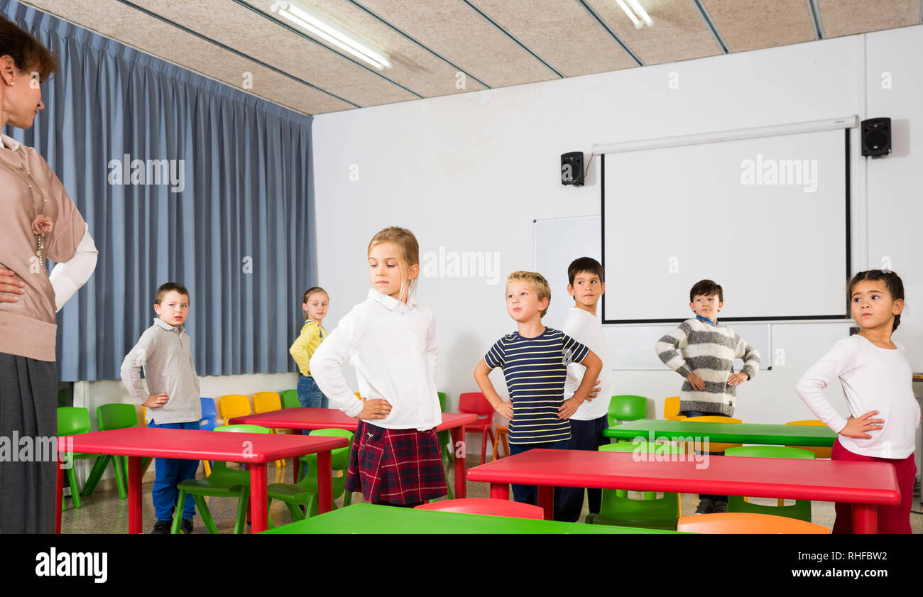 Portrait of schoolchildren with teacher performing daily physical ...