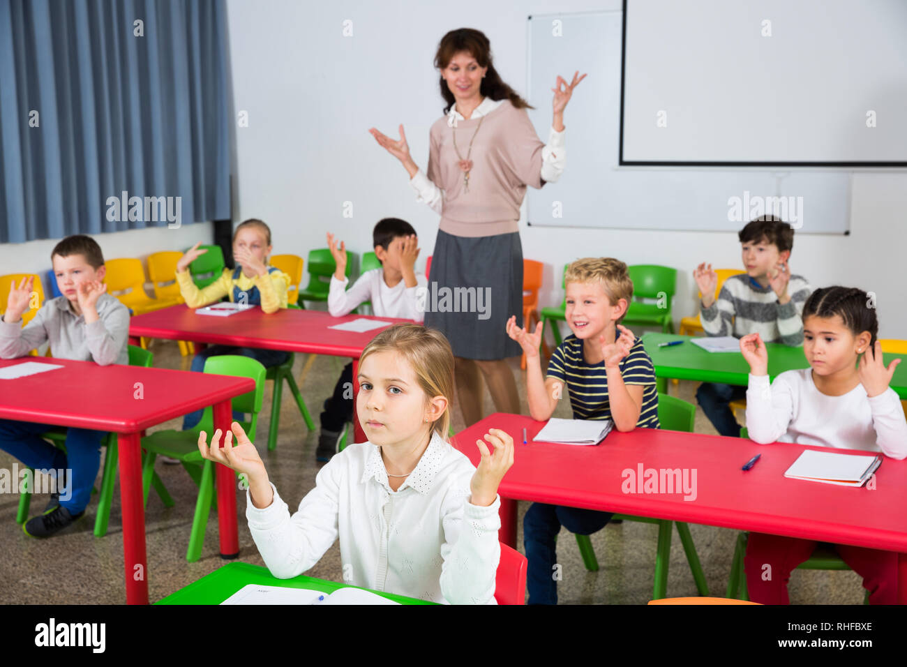 Portrait of schoolchildren with teacher performing daily physical ...