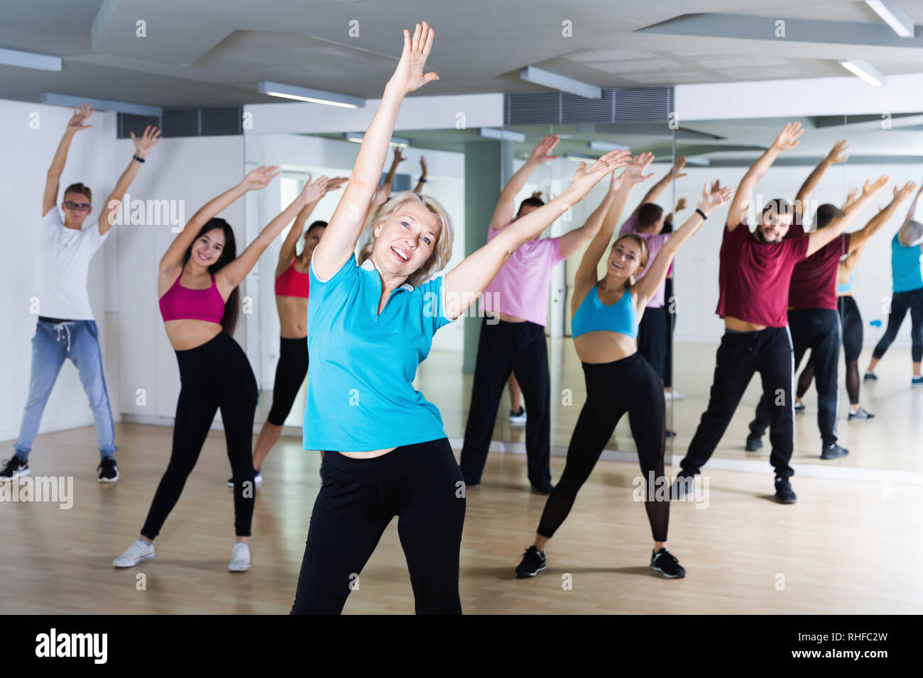 Group of smiling people of different ages dancing in studio Stock Photo ...