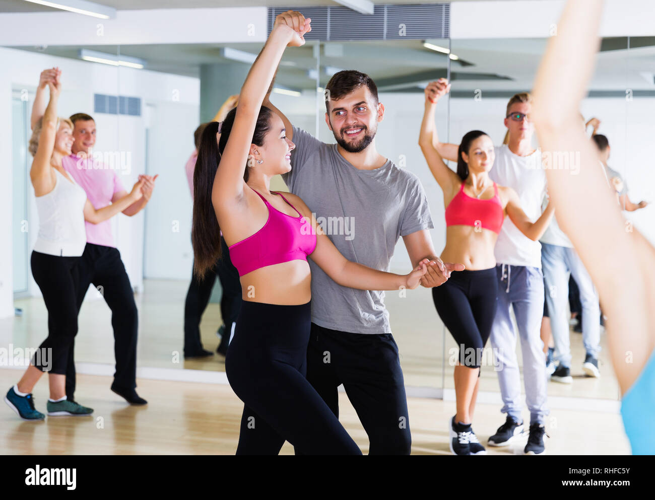 Group of active happy young adults dancing salsa in club Stock Photo ...