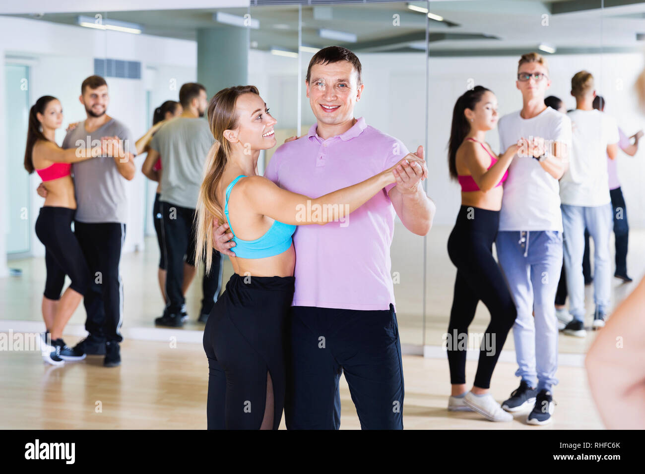 Happy cheerful people of different ages having dancing class in ...