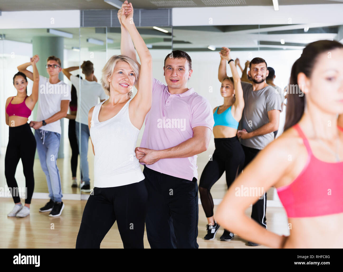 glad different ages people having dancing class in classroom Stock ...