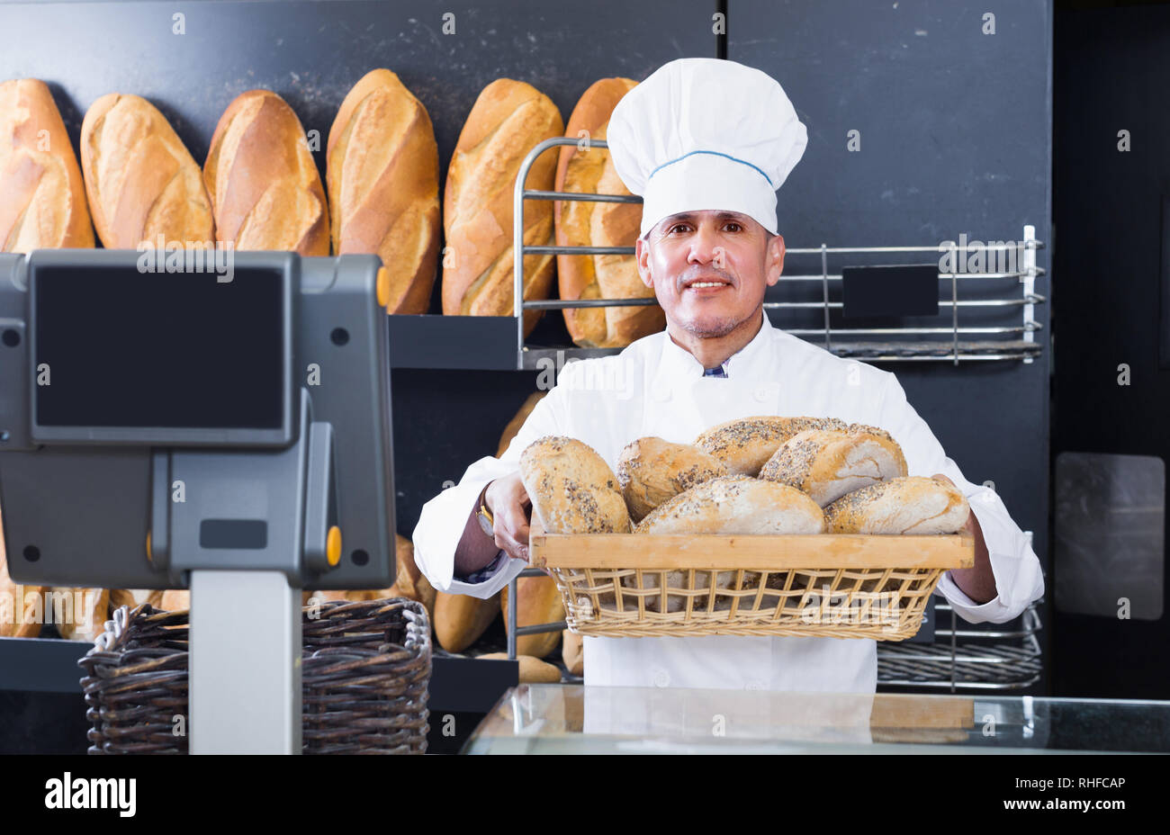 Smiling male baker is showing tasty bread in bakery Stock Photo - Alamy
