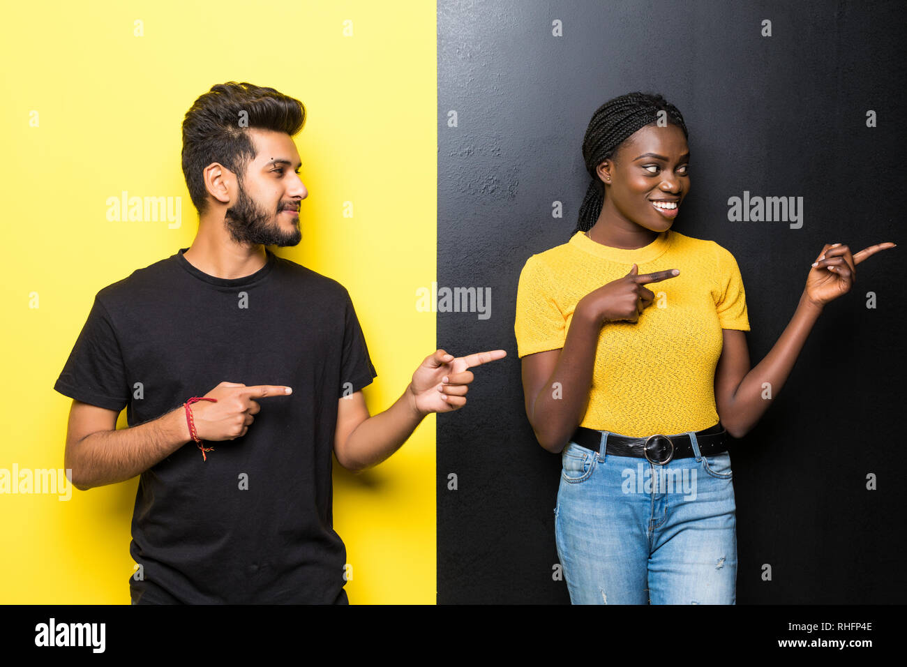 Young happy mixed race couple, indian man and african woman pointed ...