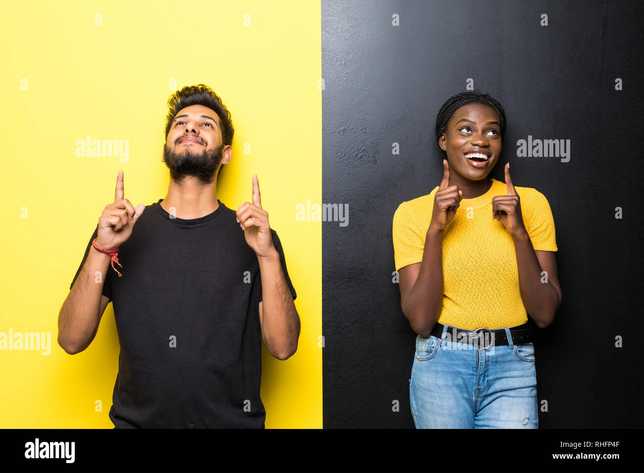 Young happy mixed race couple, indian man and african woman pointed up ...