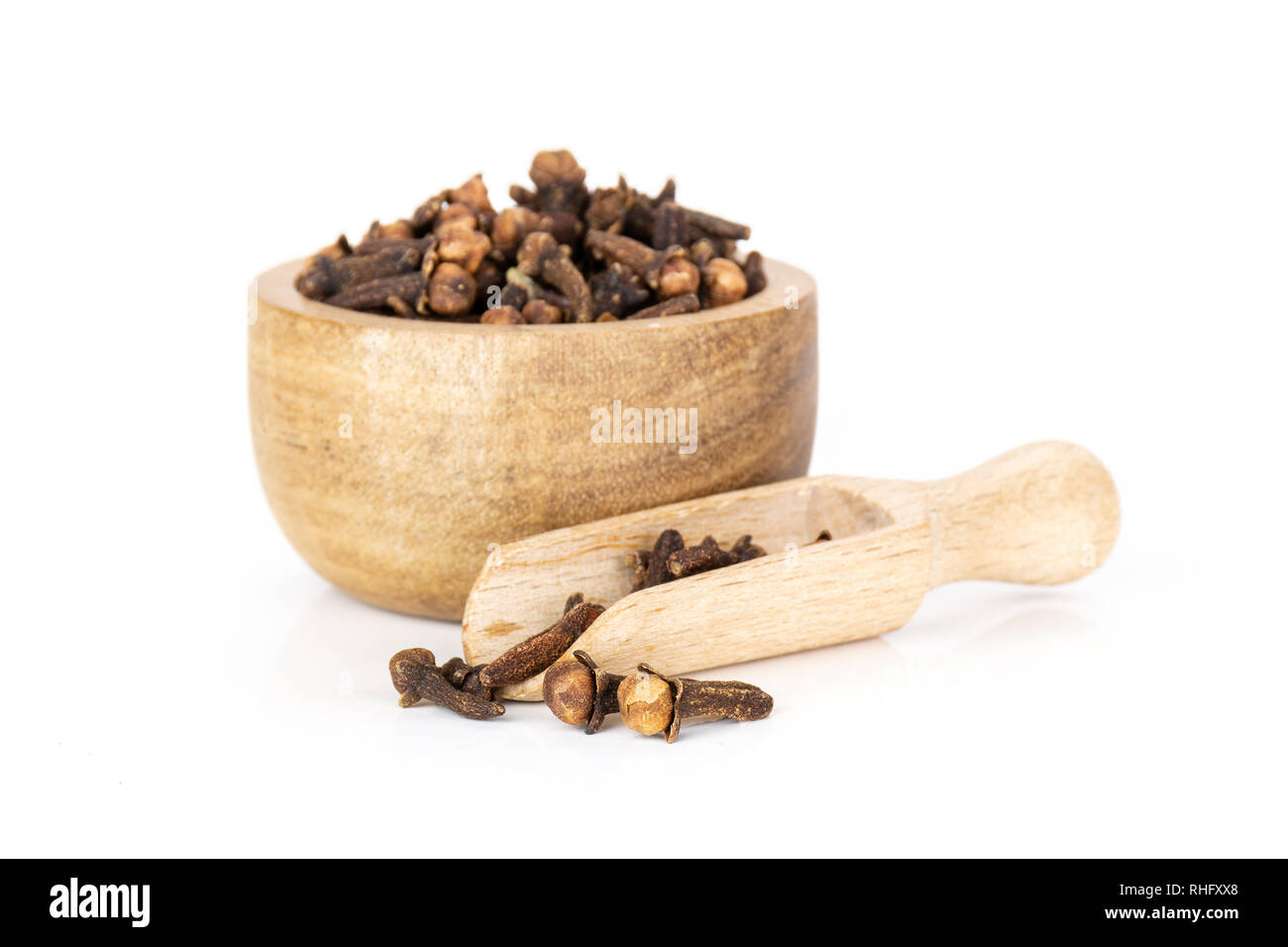 Lot of whole small dried cloves spice scoop with wooden bowl isolated ...