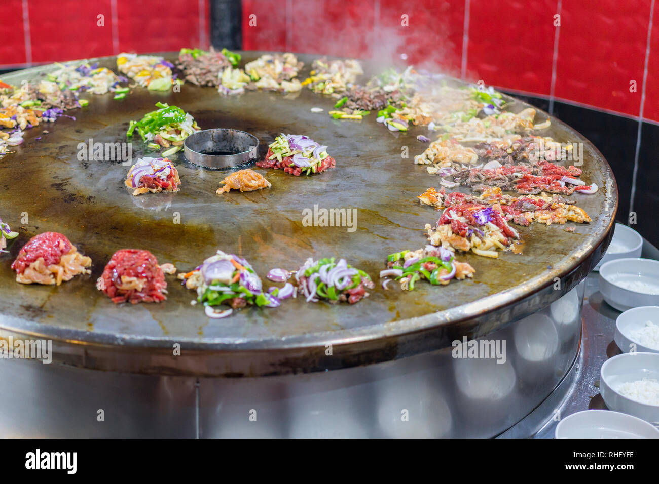 Cooking street food on a large firebox. Frying meat and seafood on the ...