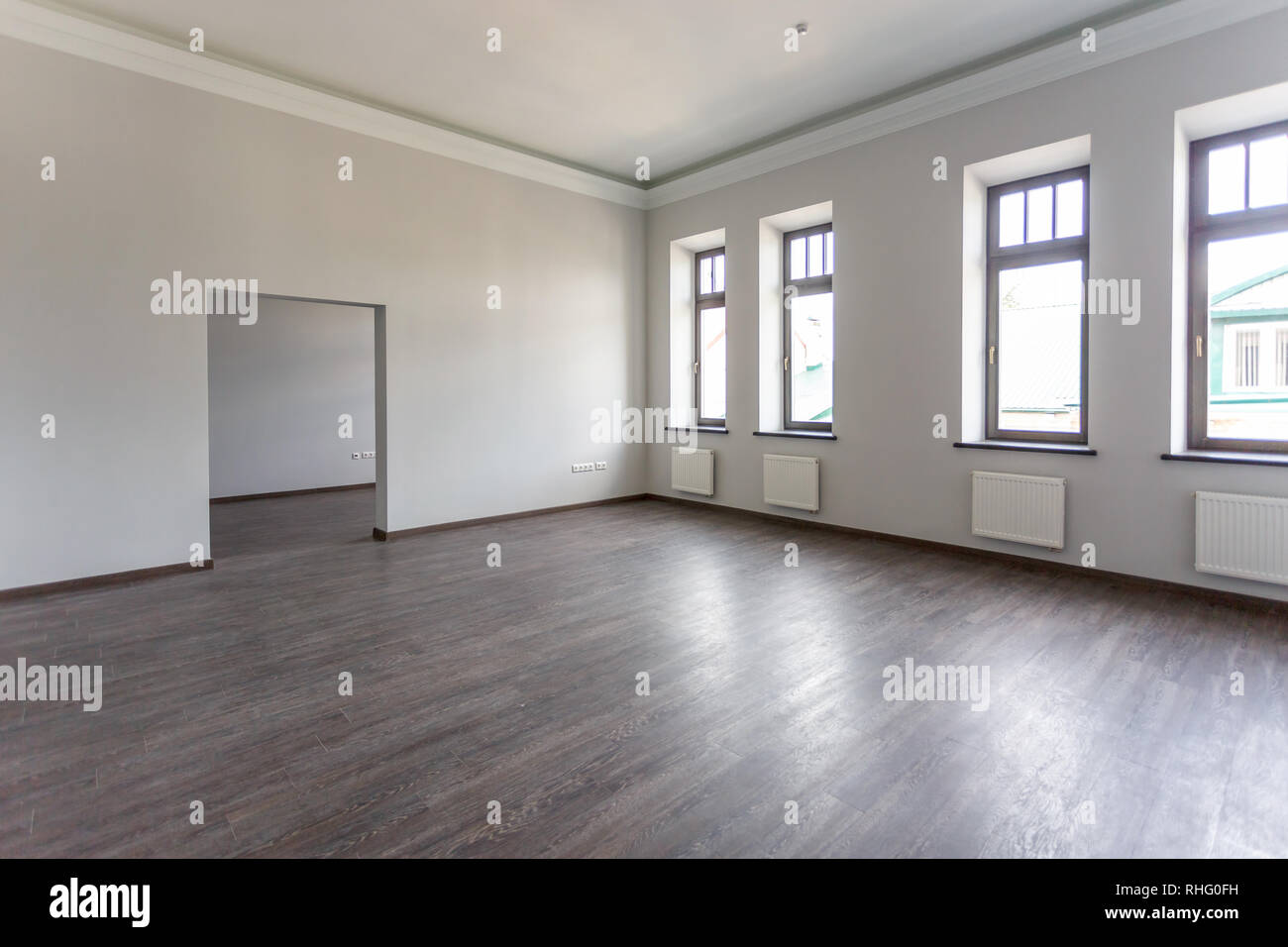 Side view of unfurnished room loft interior with wooden floor, white ...