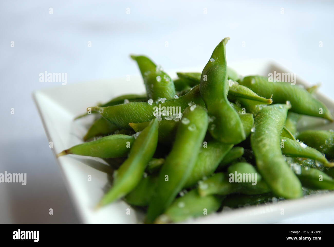 Dish of fresh japanese edamame soybeans with salt Stock Photo - Alamy