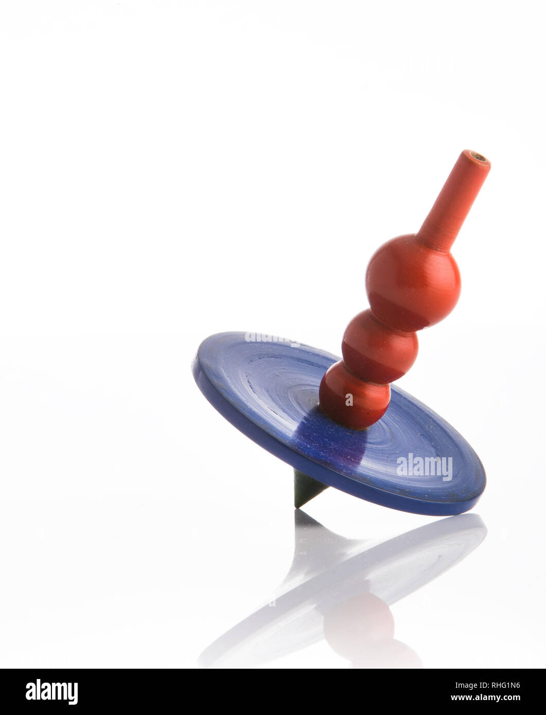 Retro wooden toy spinning top on white background with reflection Stock ...