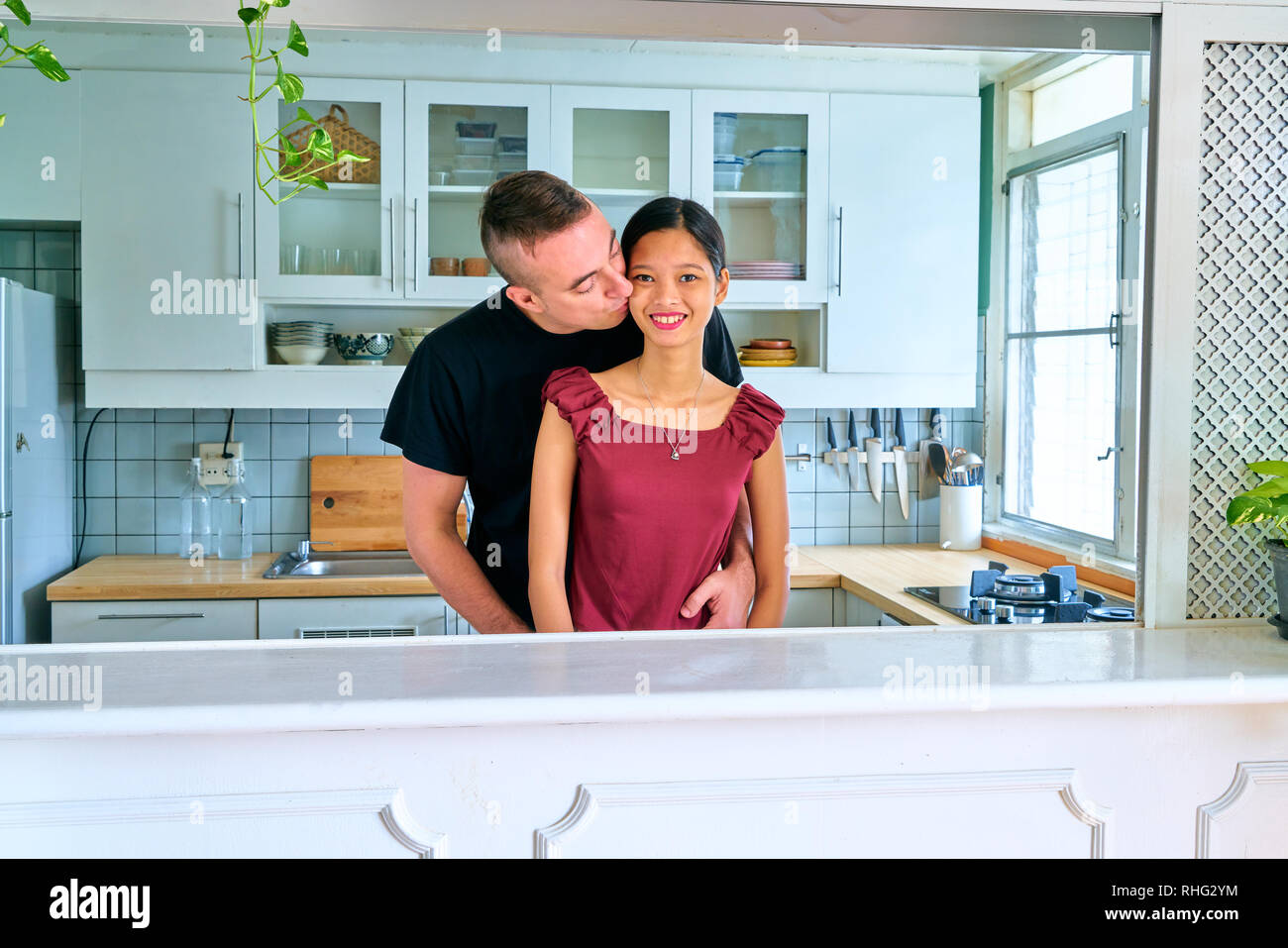 Lovely couple posing - kissing on cheek and hugging Stock Photo - Alamy