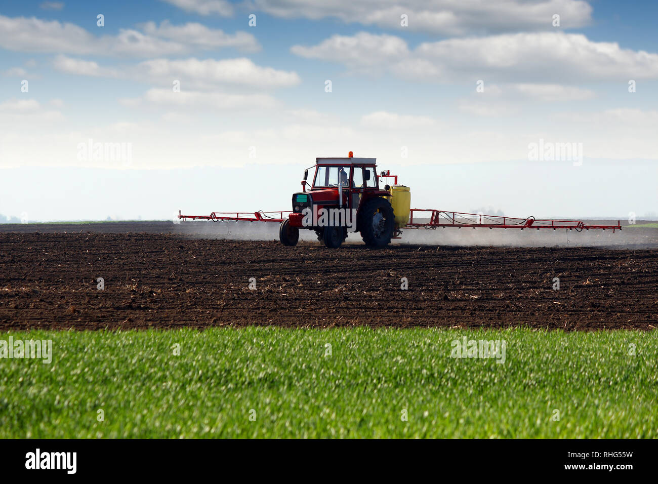 tractor spraying field at spring agriculture Stock Photo - Alamy