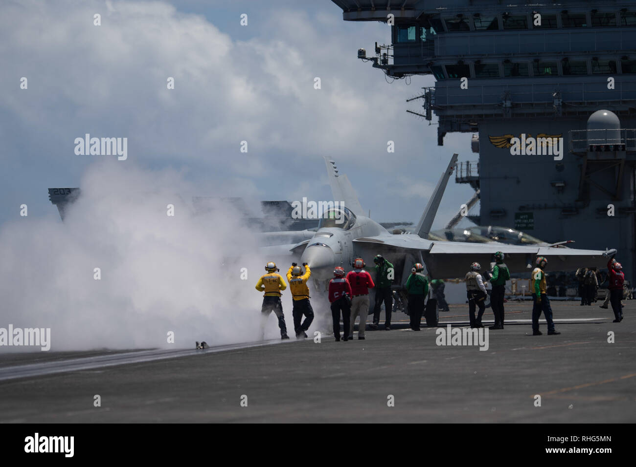 U.S. Sailors direct an F/A-18E Super Hornet, assigned to Strike Fighter ...