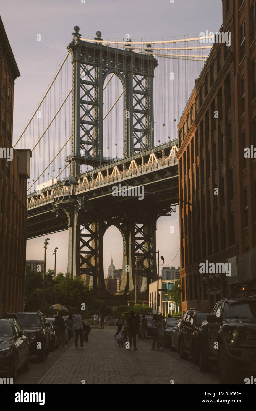 Brooklyn Bridge between industrial buildings during the day, New York ...