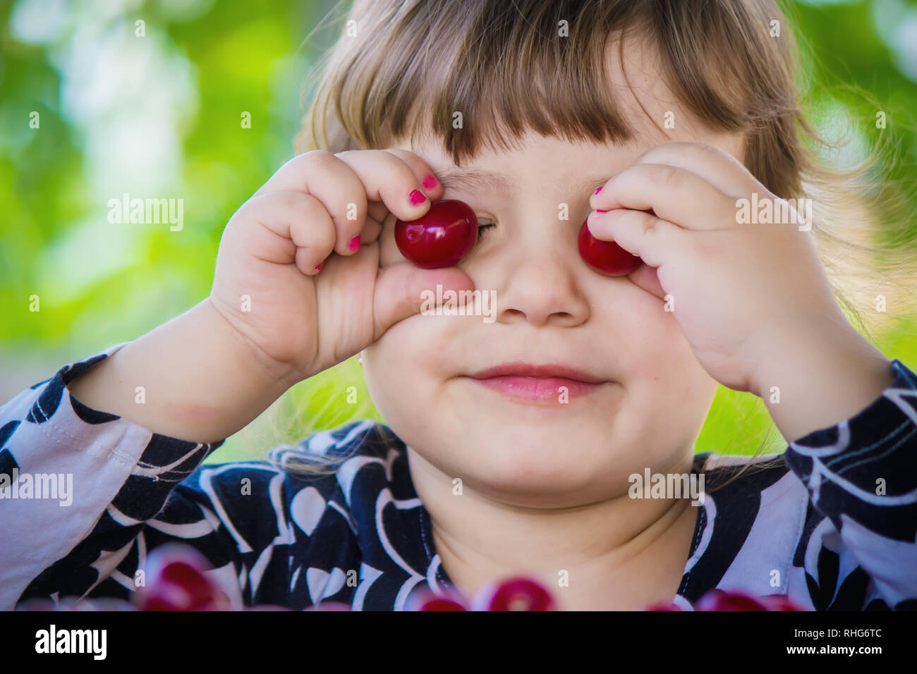 The child is picking cherries in the garden. Selective focus Stock ...