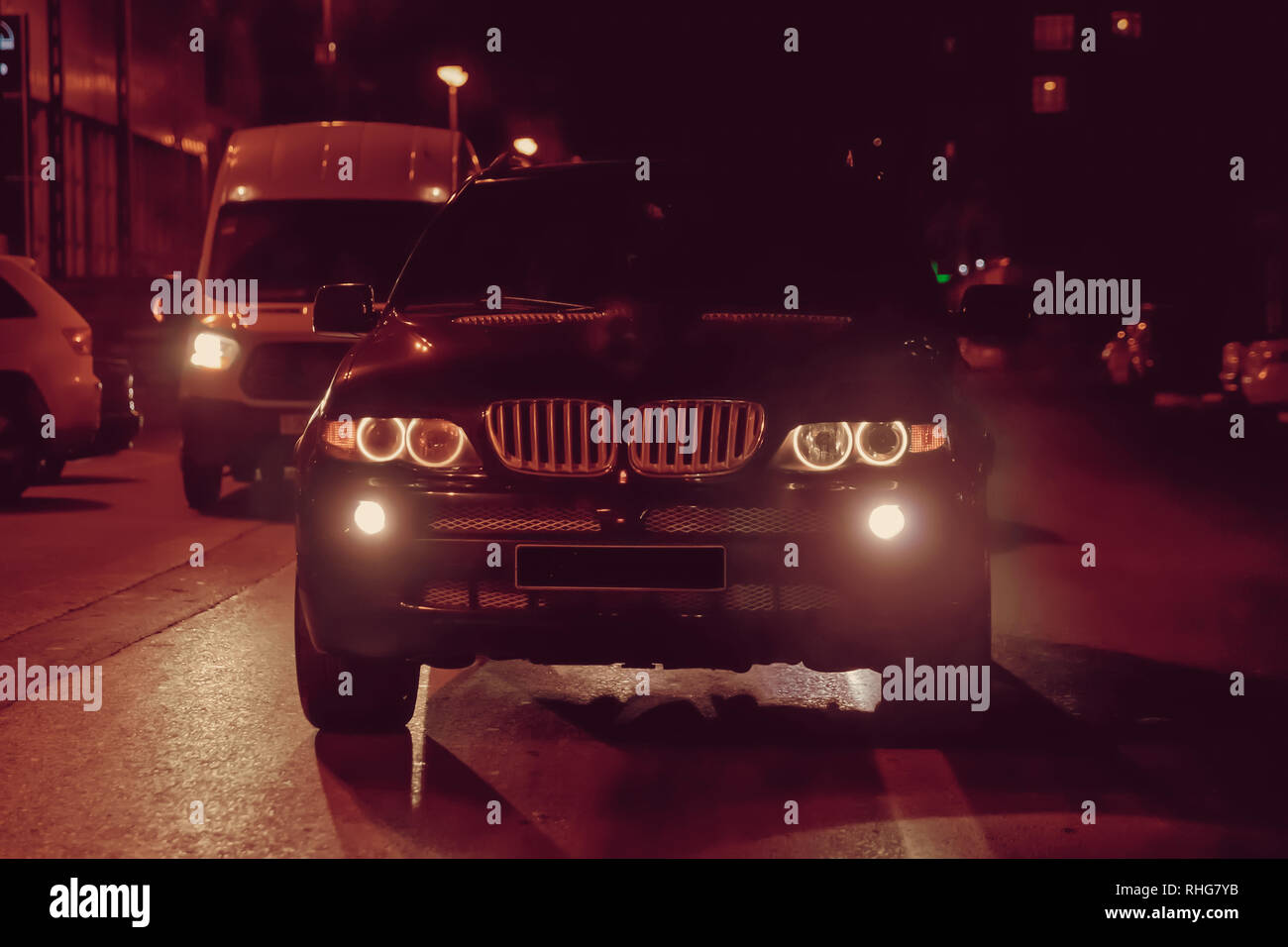 Road in the city at the night with yellow and red electrical light for ...