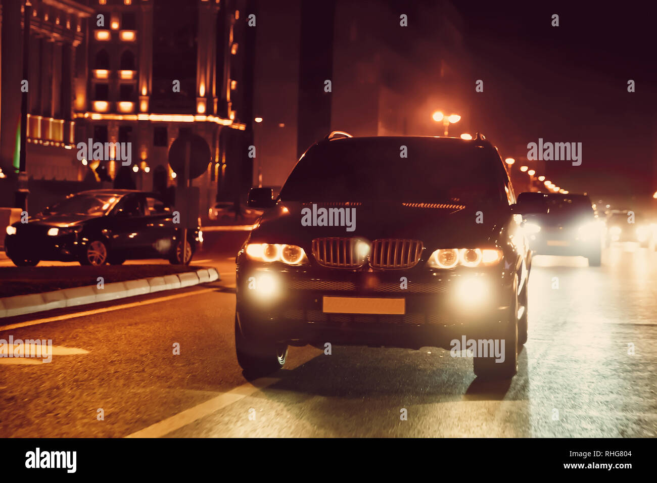 Road in the city at the night with yellow and red electrical light for ...
