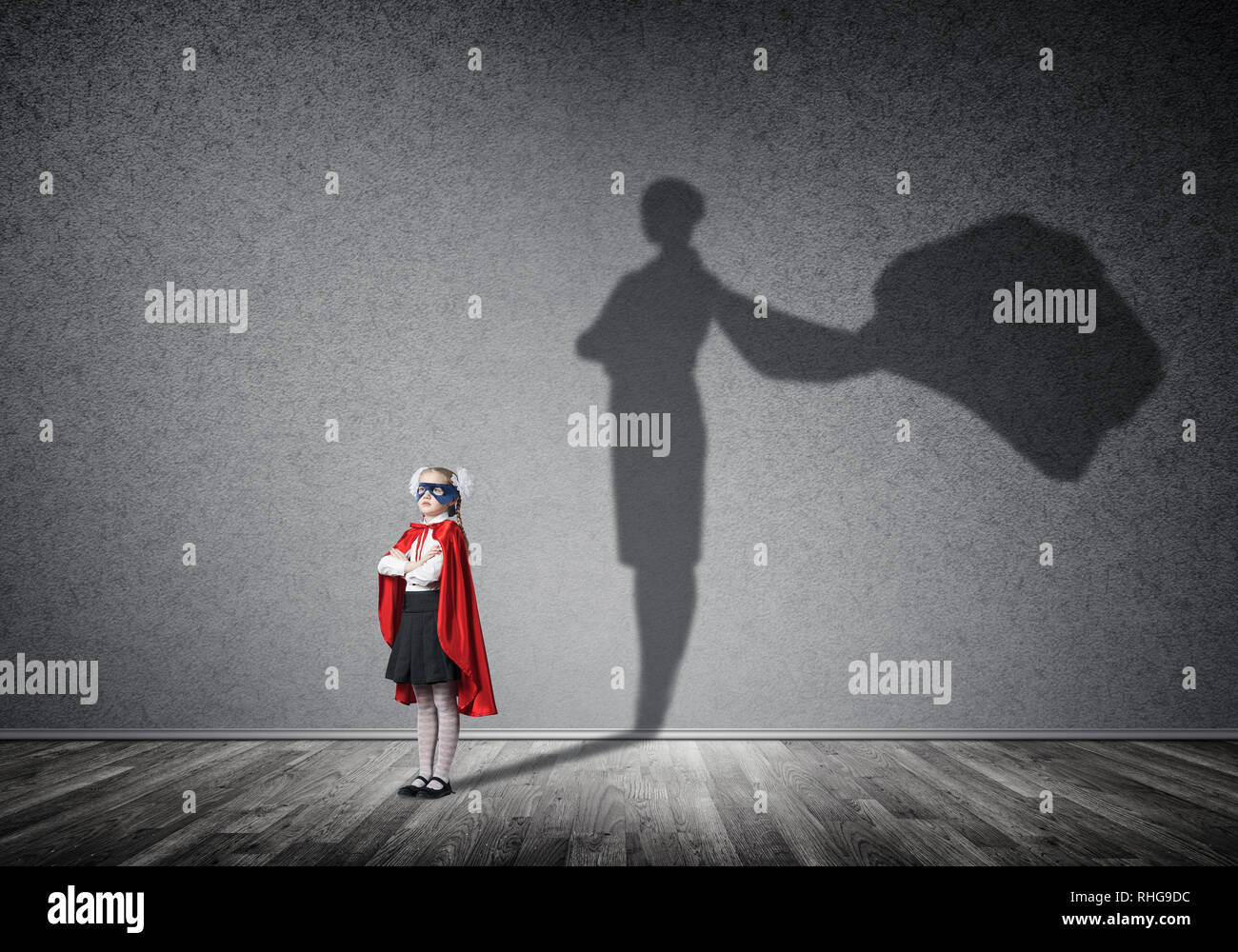 Girl power concept with cute kid guardian and shadow on wall. Mixed ...