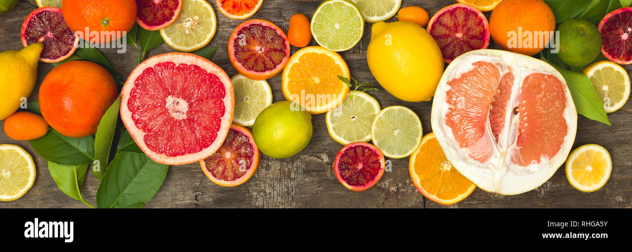 many different juicy and healthy citrus fruits lie together on an old ...