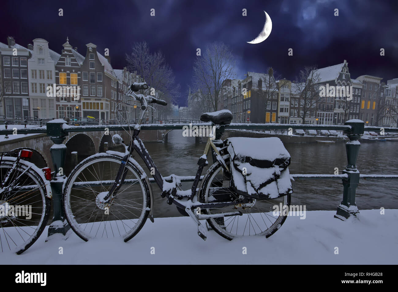 City scenic from snowy Amsterdam in the Netherlands in winter at night ...