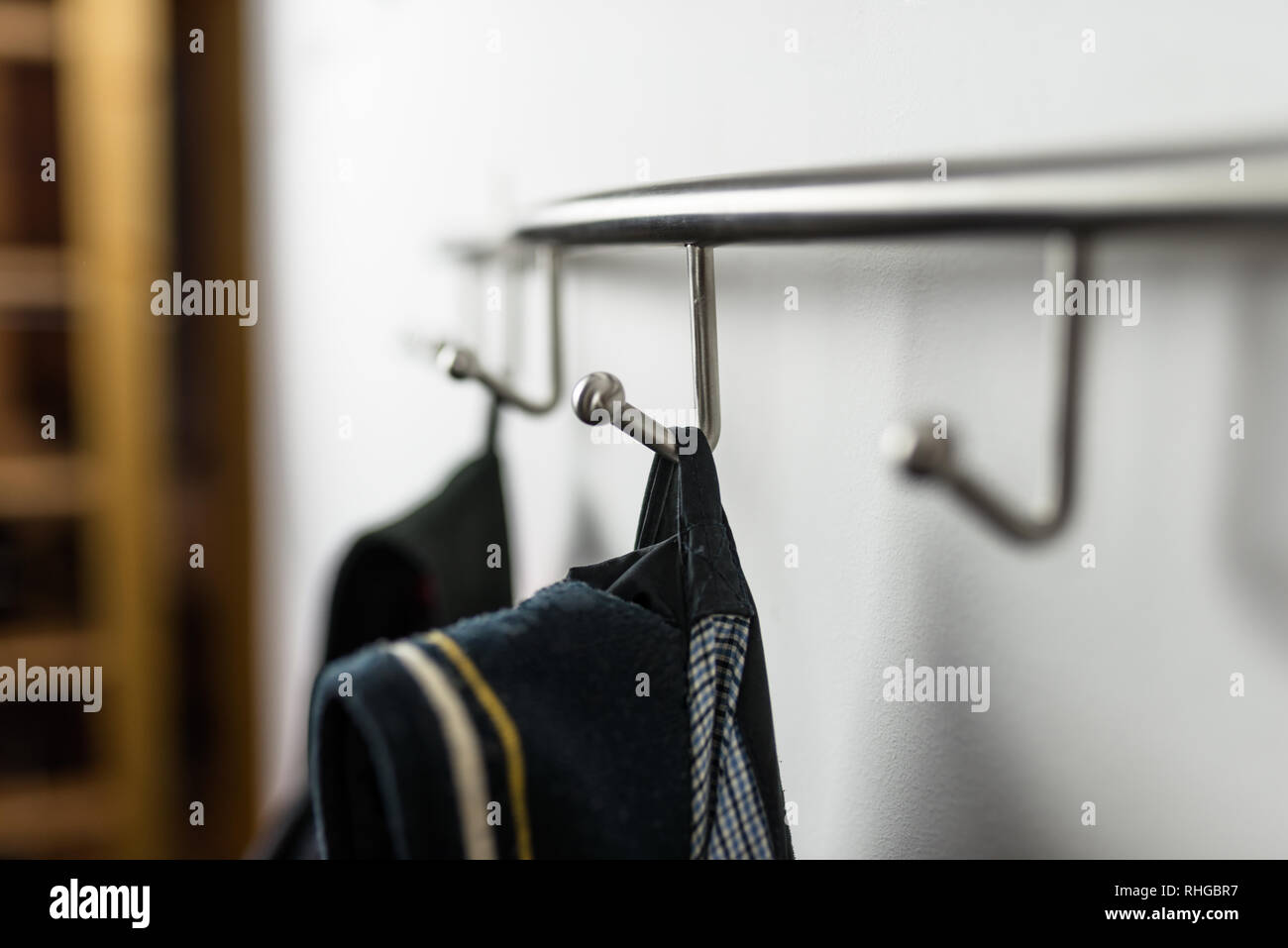 Dark mens jackets hanging on a hook in hause, on a wall hanger Stock ...