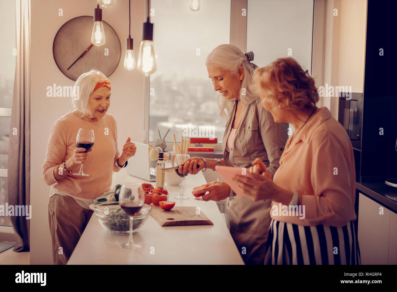 Joyful aged woman giving advice to her friends Stock Photo - Alamy