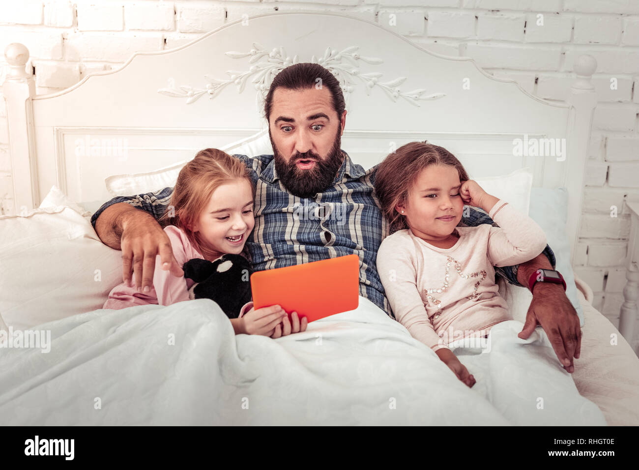 Positive nice emotional man hugging his daughters Stock Photo - Alamy