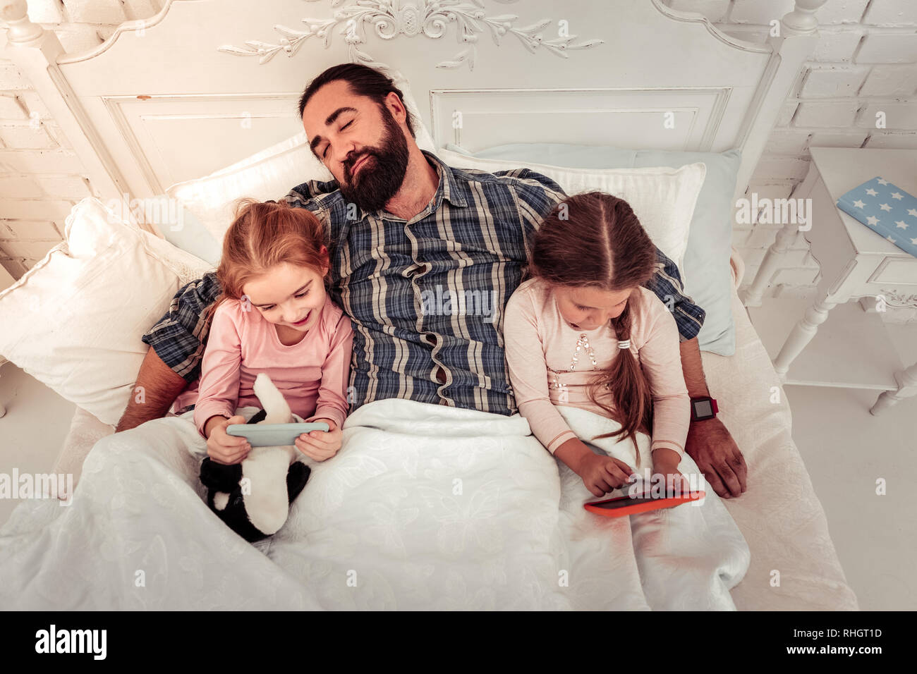 Nice tired man falling asleep on the bed Stock Photo - Alamy