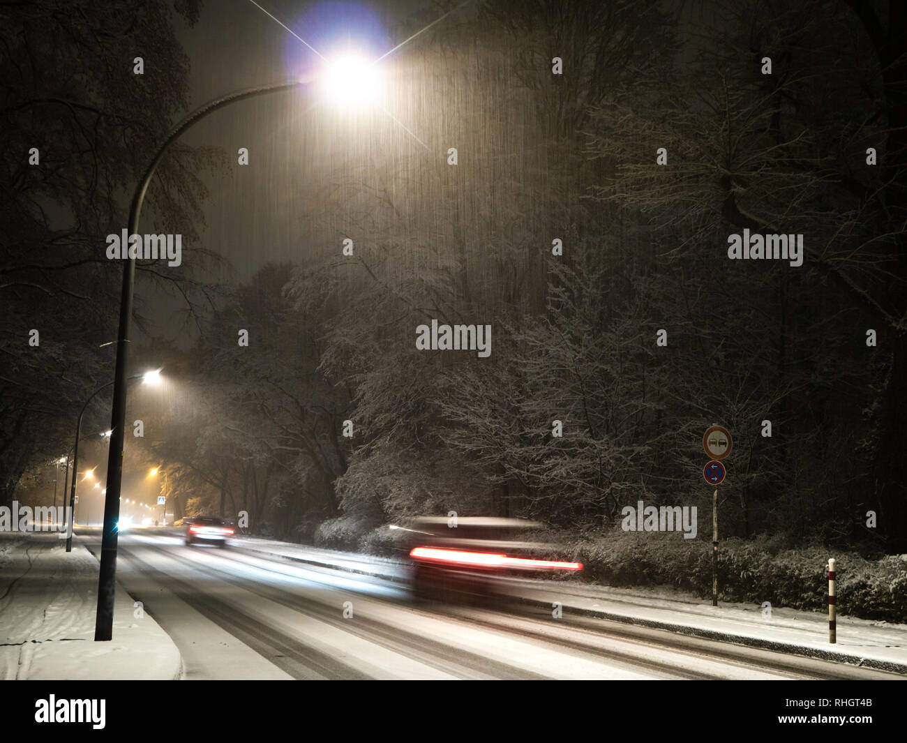 Snowy street with street lights at night,Car with motion blur driving ...