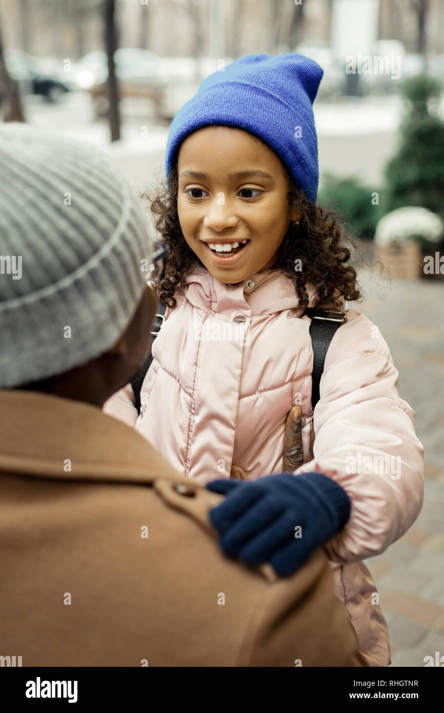 Curly daughter wearing pink winter jacket hugging father Stock Photo ...