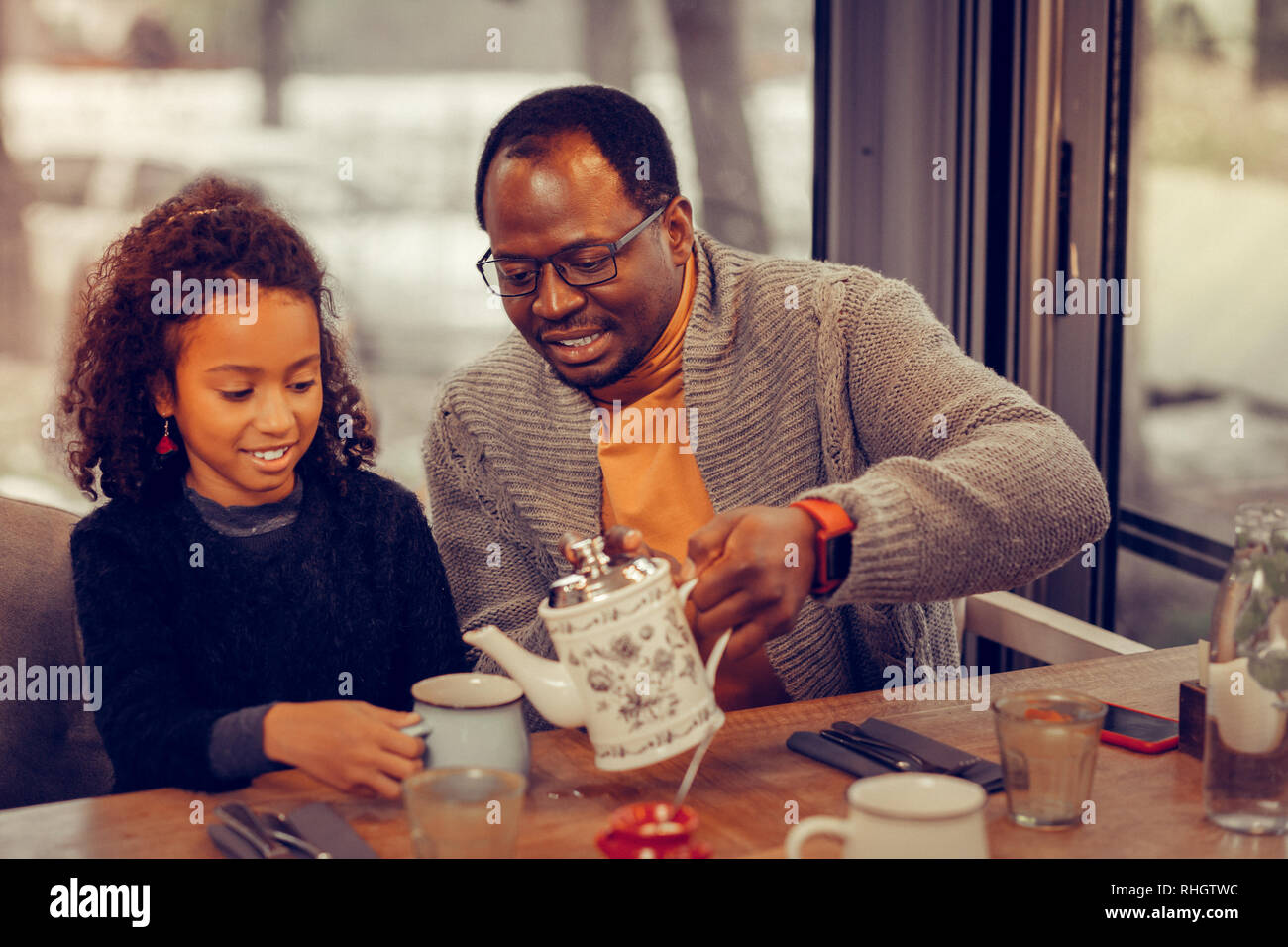 Father and daughter drinking tasty tea in cafeteria together Stock ...