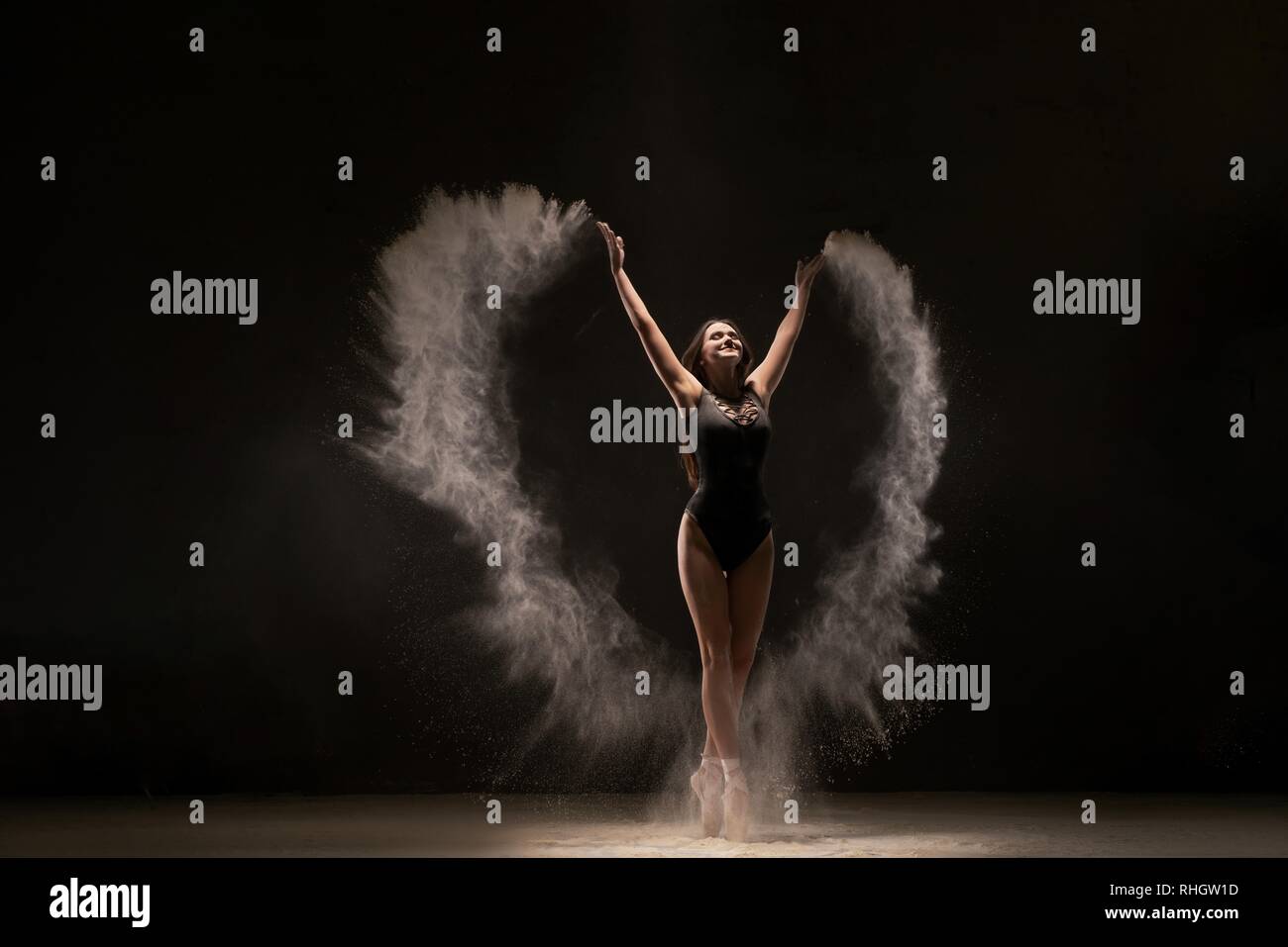 Emotional dancer in flying white powder in dark Stock Photo - Alamy