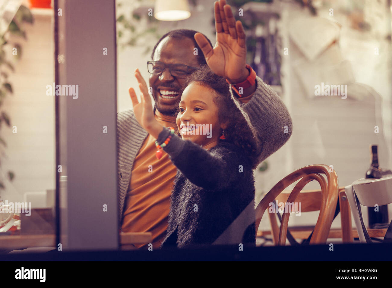 Father and daughter waving while seeing mother through the window Stock ...