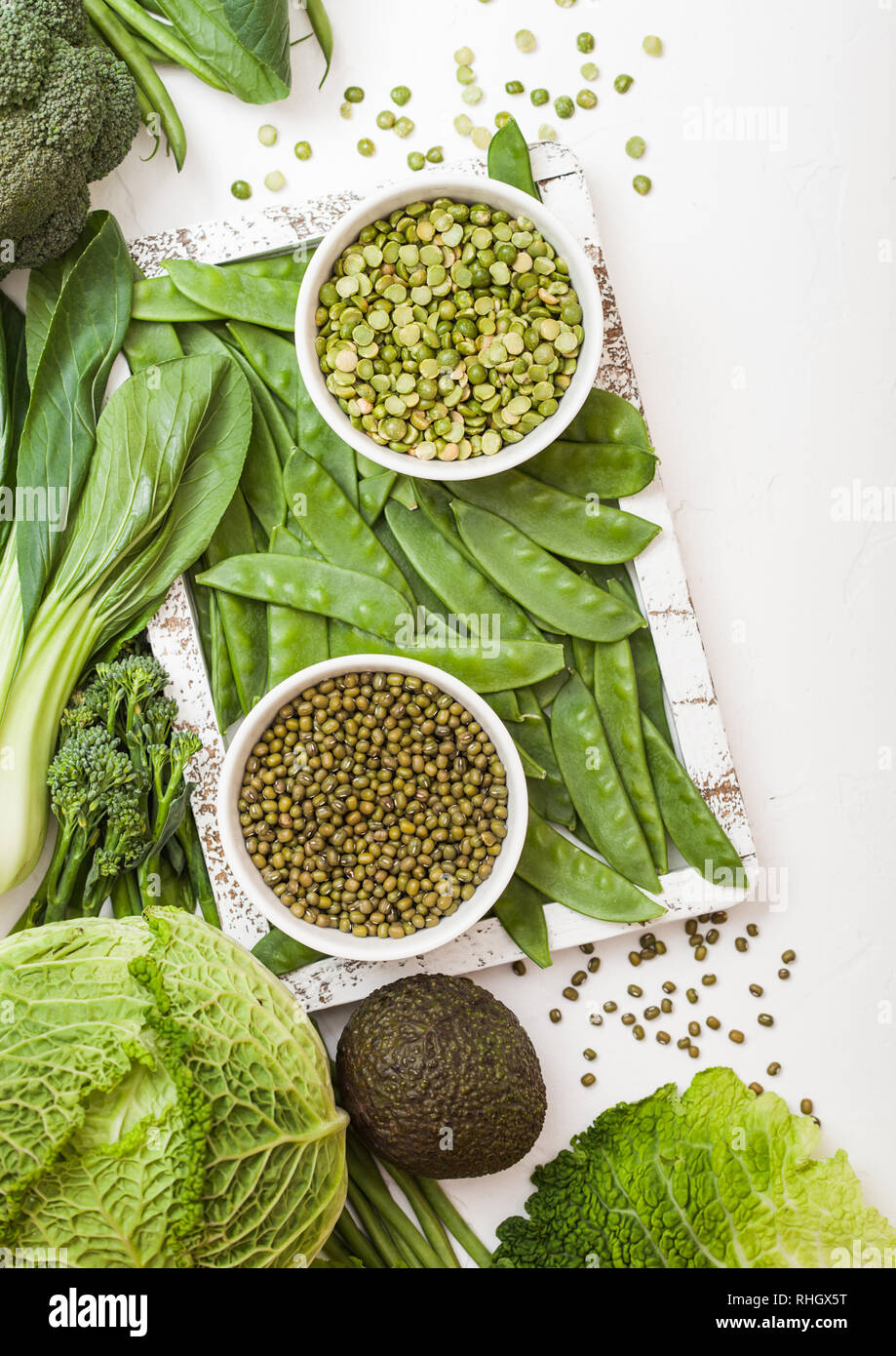 Assorted green toned raw organic vegetables on white background ...
