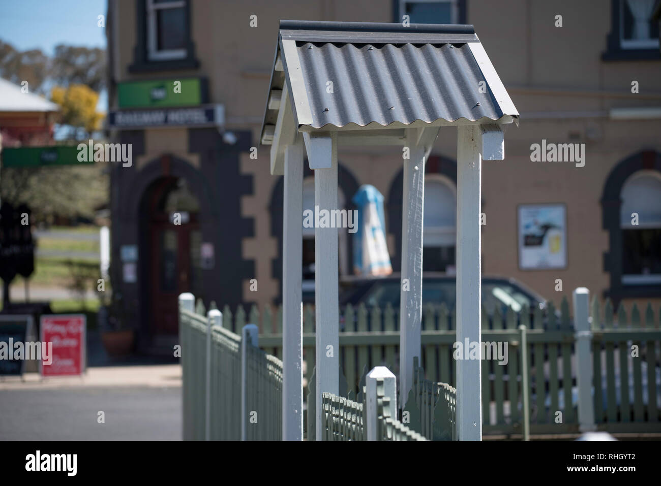 A small timber and tin roofed, arched gate sits neatly between a line ...